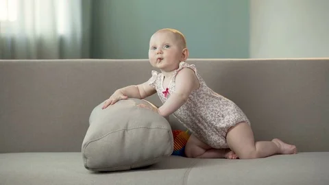 Funny happy baby girl jumping on sofa, d... | Stock Video | Pond5