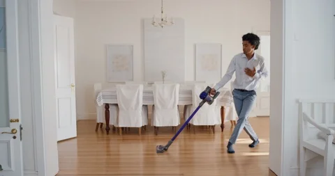 funny man dancing with vacuum cleaner at... | Stock Video | Pond5