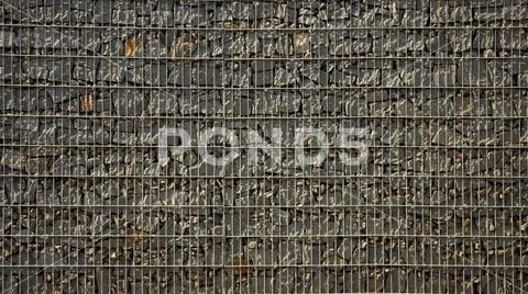 Gabion, a stone wall with a metal grid of gray granite texture ~ Hi Res ...