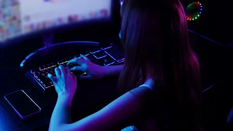 Gamer girl tapping on her neon keyboard | Stock Video | Pond5