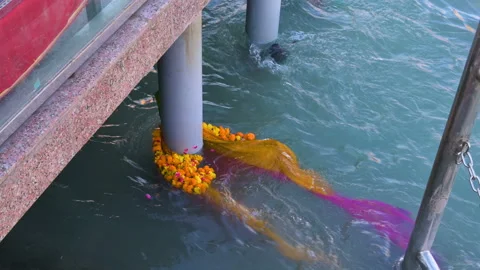 Garland floating on Holy river Ganges at... | Stock Video | Pond5