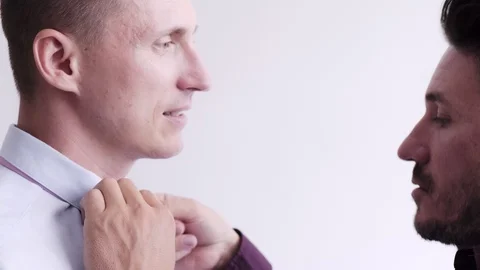 Gay man help his partner putting on tie ... | Stock Video | Pond5