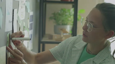 Gen Z Girl Writing on Sticky Notes Attac... | Stock Video | Pond5