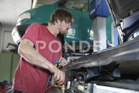Germany, Ebenhausen, Mechatronic Technician Working In Car Garage ...