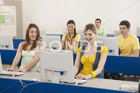 Germany, Emmering, Students using computer in computer lab, smiling ...