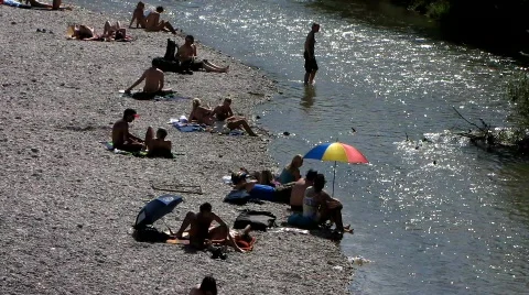 Germany Munich Sunbathing on stone beach | Stock Video | Pond5