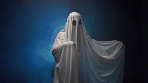 Ghost in sheet dancing in blue smoke ove... | Stock Video | Pond5