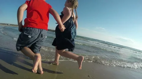 girl and boy running through the water a... | Stock Video | Pond5