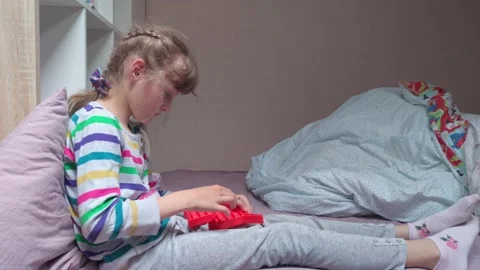 Girl With Antistress Toy On The Bed | Stock Video | Pond5