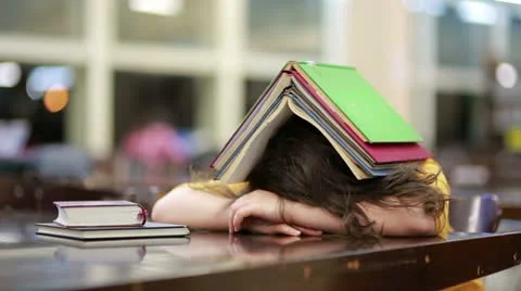 Girl asleep buried under book stack in l... | Stock Video | Pond5