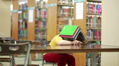 Girl asleep buried under book stack in l... | Stock Video | Pond5