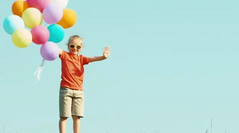 Girl with balloons waving hand at camera... | Stock Video | Pond5