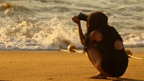 Girl on the beach with a camera | Stock Video | Pond5