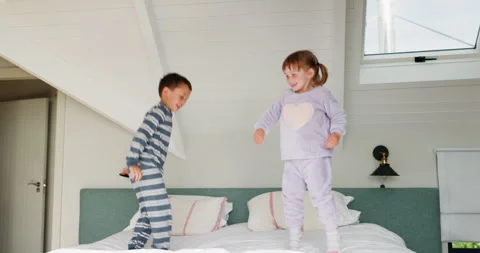 Girl, boy and children on bed, jump and ... | Stock Video | Pond5