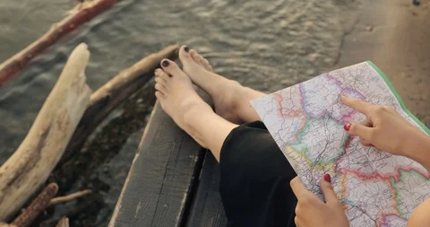 Girl is choosing travel route on map sit... | Stock Video | Pond5
