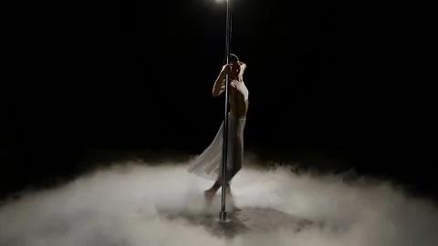 Girl dancing on a pole in smoke studio. ... | Stock Video | Pond5