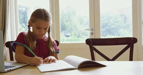 Girl doing homework at dining table in a... | Stock Video | Pond5
