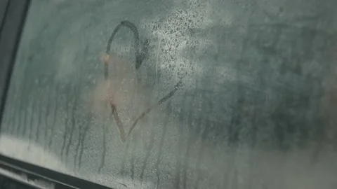 Girl Drawing Heart on Foggy Car Window | Stock Video | Pond5