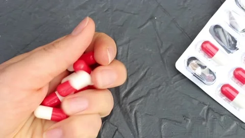 Girl holds red capsules in her hand on g... | Stock Video | Pond5