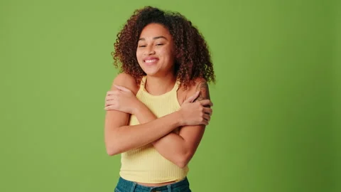 A girl hugging herself on a green screen... | Stock Video | Pond5