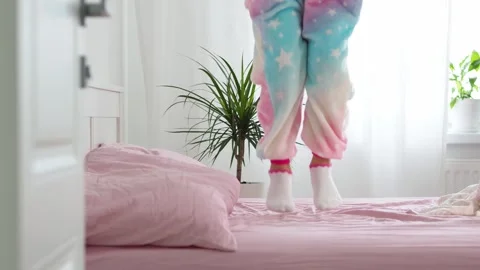 The girl is jumping on the bed. Home par... | Stock Video | Pond5