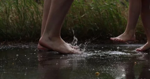 Girl jumping through the puddles barefoo... | Stock Video | Pond5