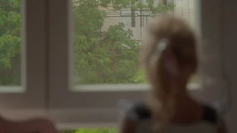 Girl looking outside through the window | Stock Video | Pond5