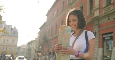 A girl is looking for a place on a map o... | Stock Video | Pond5