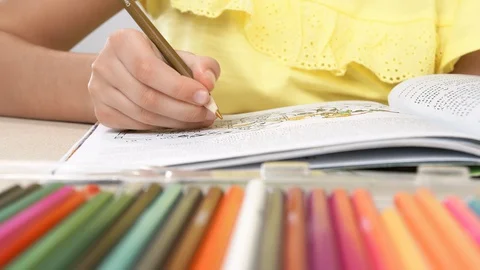 A girl paints a coloring book. Close-up ... | Stock Video | Pond5