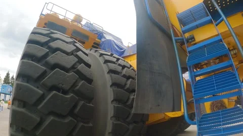 A girl passing under a large dump truck.... | Stock Video | Pond5