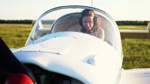 Girl pilot sitting in airplane cockpit | Stock Video | Pond5