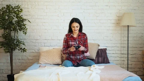 Girl playing on a console on the bed at ... | Stock Video | Pond5