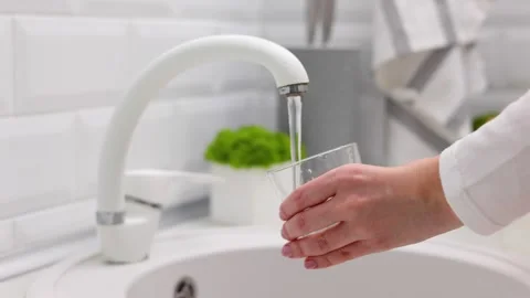 A girl pours clean water into a glass fr... | Stock Video | Pond5