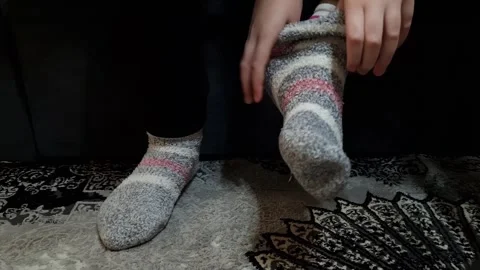 Girl putting warm socks at home | Stock Video | Pond5