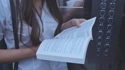 girl is reading book on elevator | Stock Video | Pond5