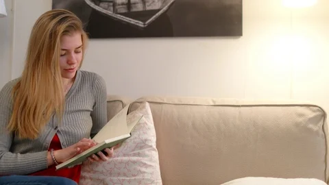 the girl is reading on the couch | Stock Video | Pond5