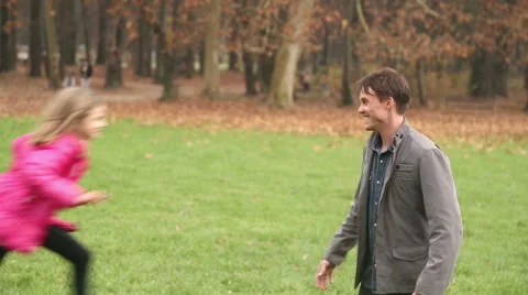 Girl running into father's arms in park | Stock Video | Pond5