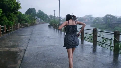 A girl is running in heavy rain at the r... | Stock Video | Pond5
