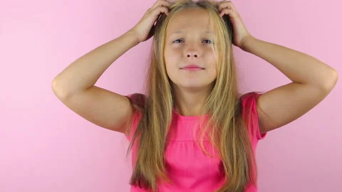 Girl scratches her head on a colored bac... | Stock Video | Pond5