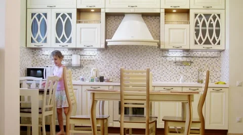 Girl sets the table in light kitchen. Ti... | Stock Video | Pond5