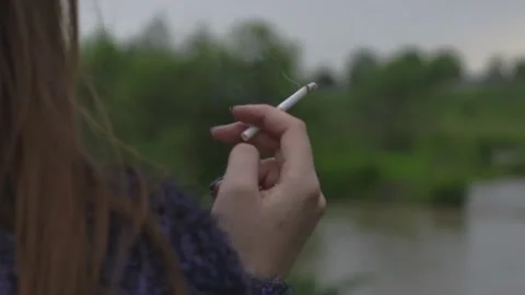 Girl smoking in nature by river slowmoti... | Stock Video | Pond5