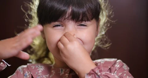 girl sniffing air and closing her nose d... | Stock Video | Pond5
