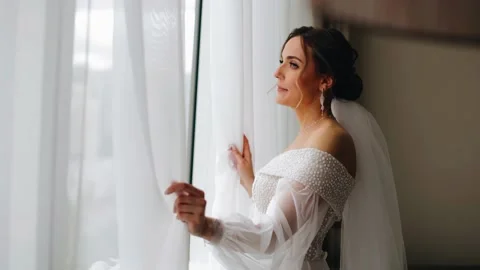 The girl is standing at the window and p... | Stock Video | Pond5