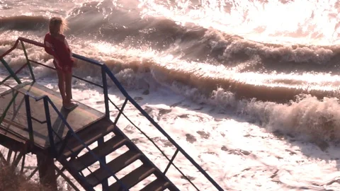 The girl on the steps watching the storm... | Stock Video | Pond5