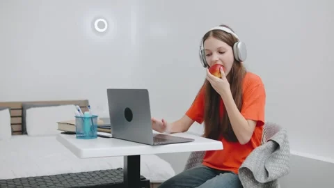Girl studying at home while eating an ap... | Stock Video | Pond5