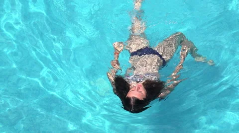 Girl swim at back in a swimming pool, 4k... | Stock Video | Pond5