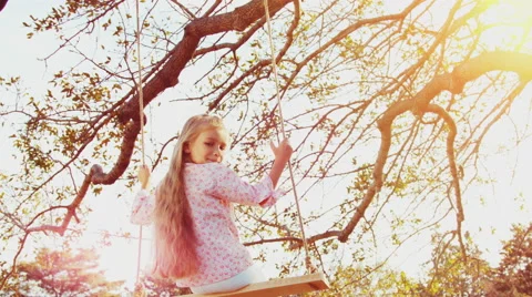 Girl on a swing back at the camera. Chil... | Stock Video | Pond5