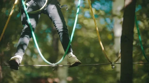 A girl walking on the rope in forest | Stock Video | Pond5