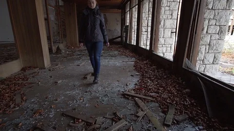 Girl walking through decaying ruins of a... | Stock Video | Pond5