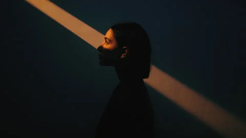 Girl watching the sunny beam light comin... | Stock Video | Pond5